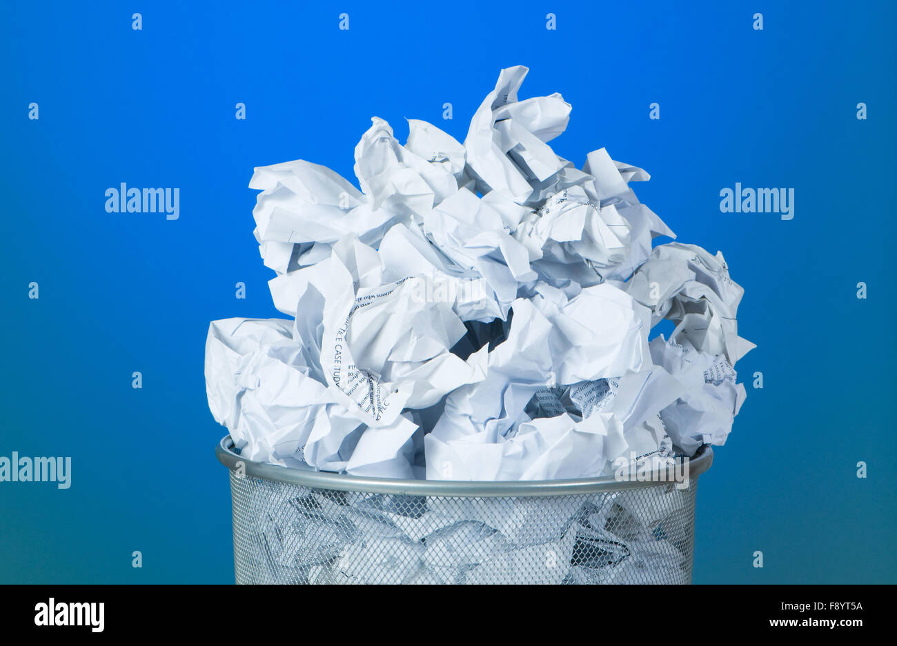 Garbage bin with paper waste against colourful background Stock Photo ...