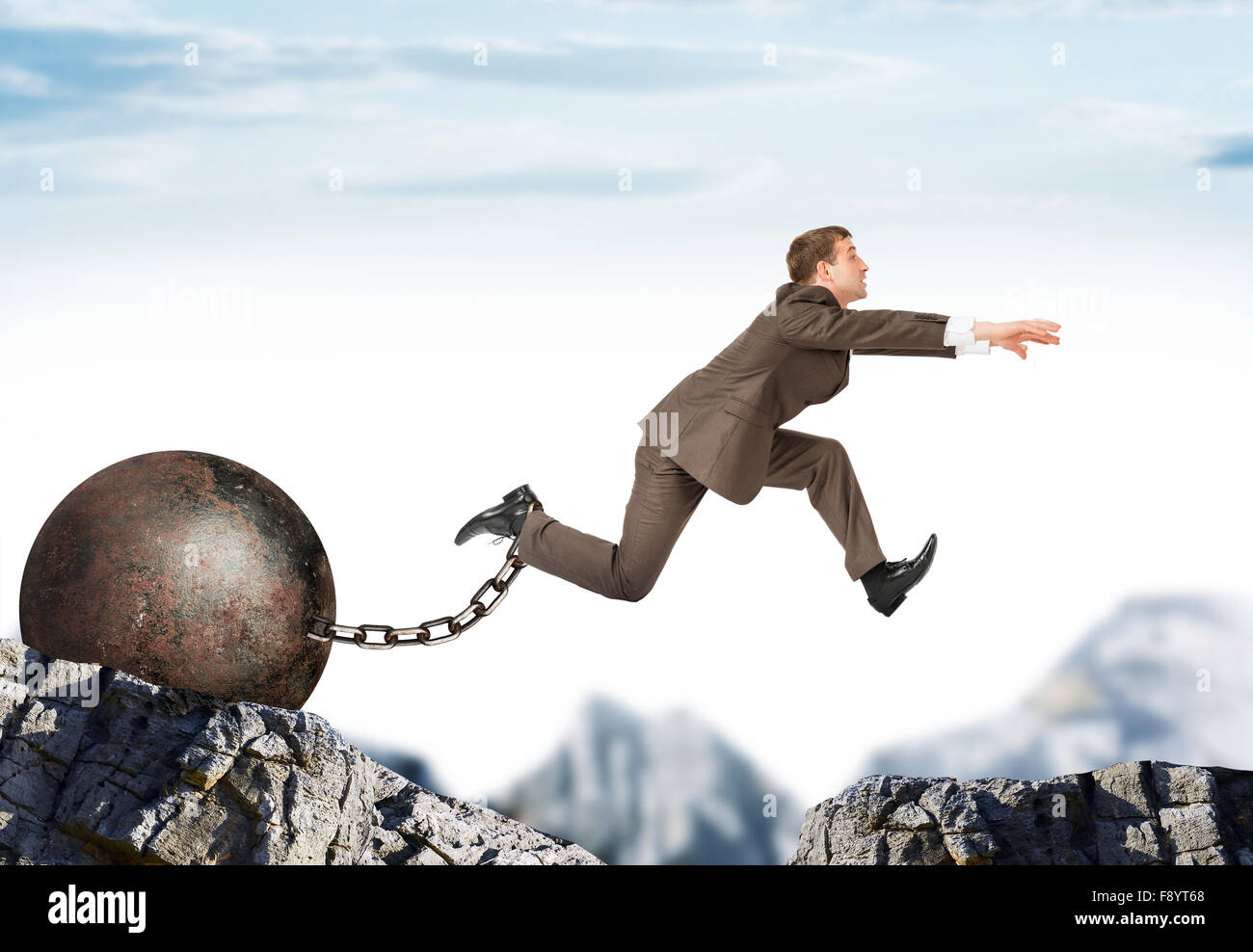 Young businessman jumping over gap Stock Photo - Alamy