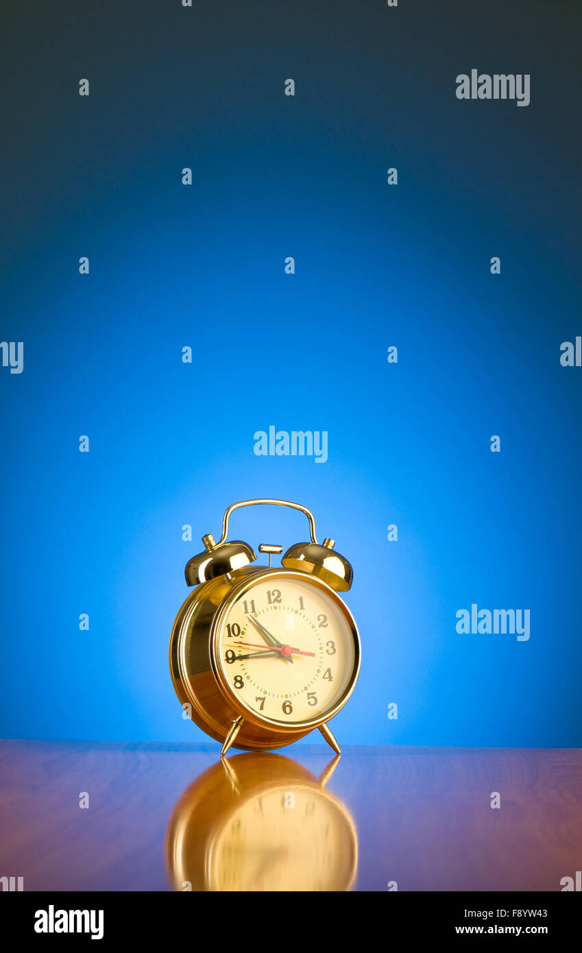 Alarm clock against colourful background Stock Photo - Alamy