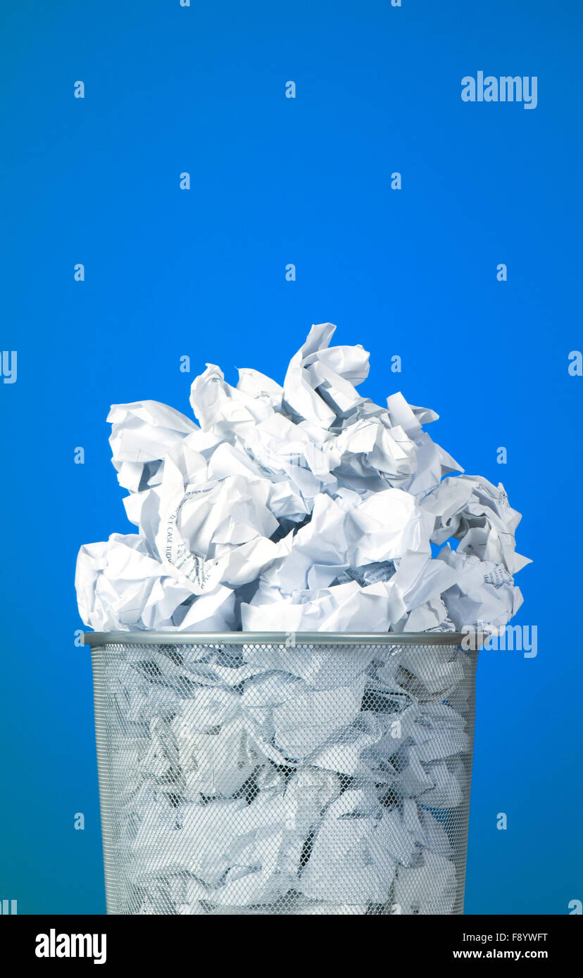 Garbage bin with paper waste against colourful background Stock Photo ...