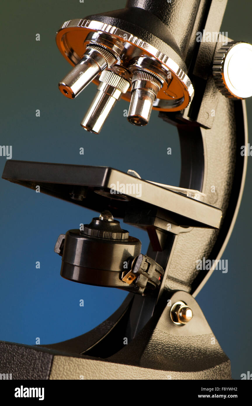 Microscope against blue gradient background Stock Photo - Alamy