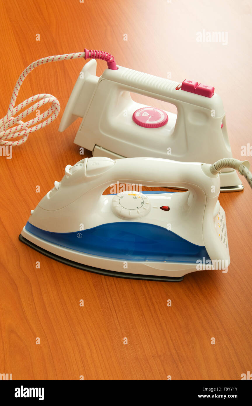 Modern electric iron on the wooden background Stock Photo - Alamy