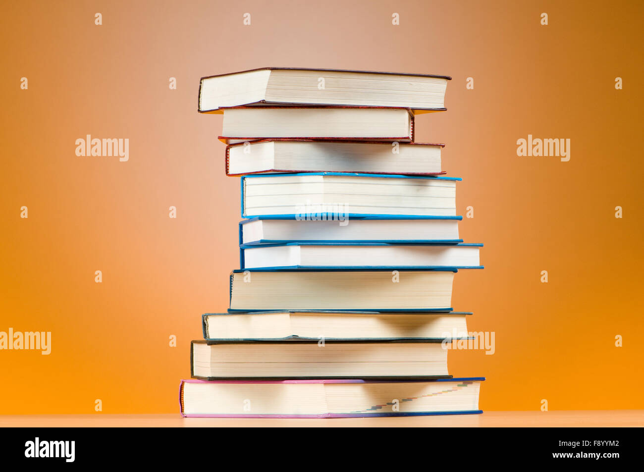 Stack of text books against gradient background Stock Photo - Alamy