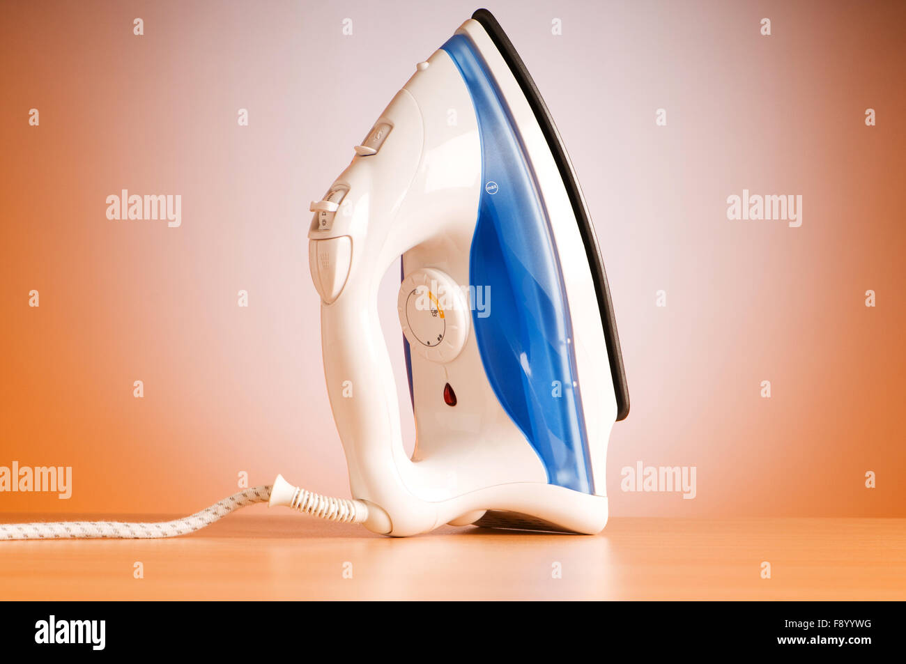 Modern electric iron against the colorful background Stock Photo - Alamy