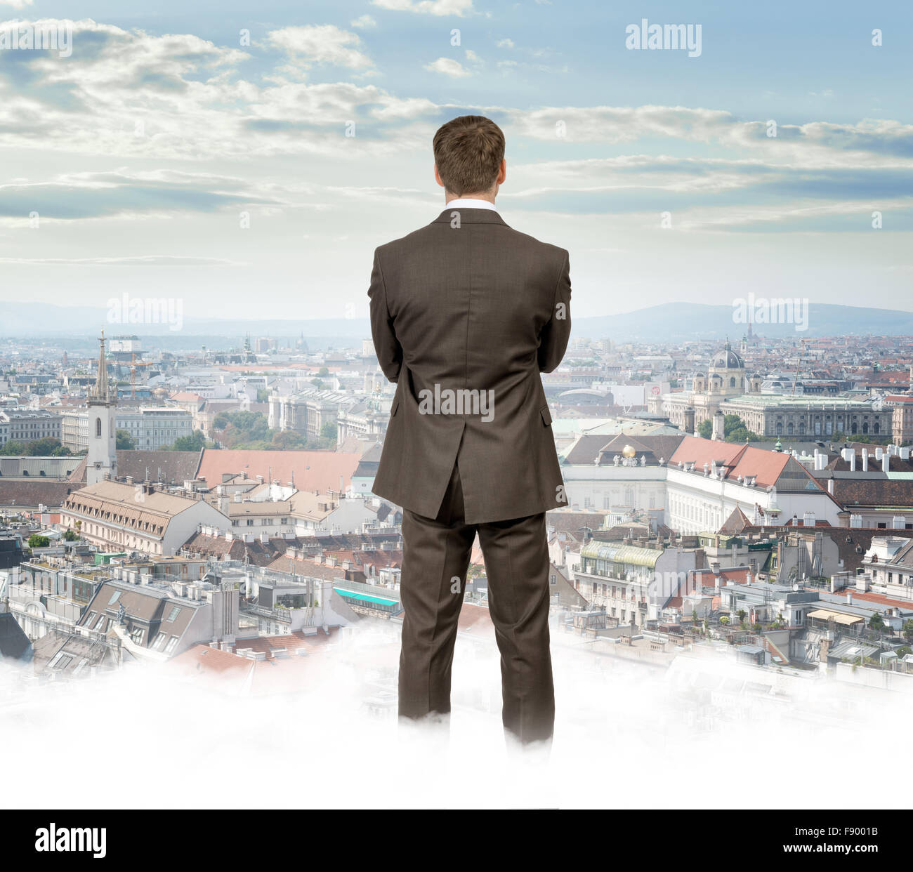 Man on clouds looking at city Stock Photo - Alamy