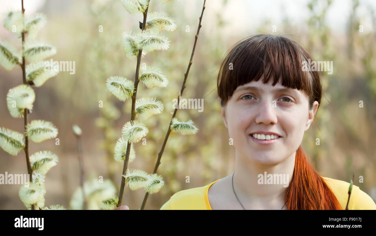 portrait of happy young woman against spring Willow branches with buds ...