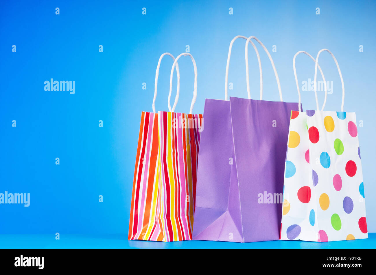 Colourful paper shopping bags against gradient background Stock Photo ...