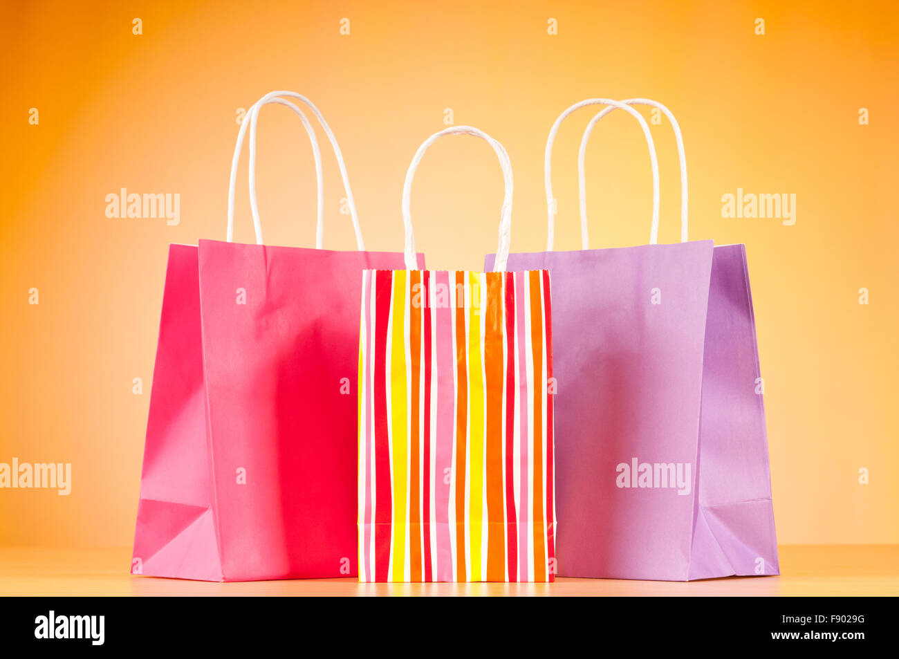 Colourful paper shopping bags against gradient background Stock Photo ...