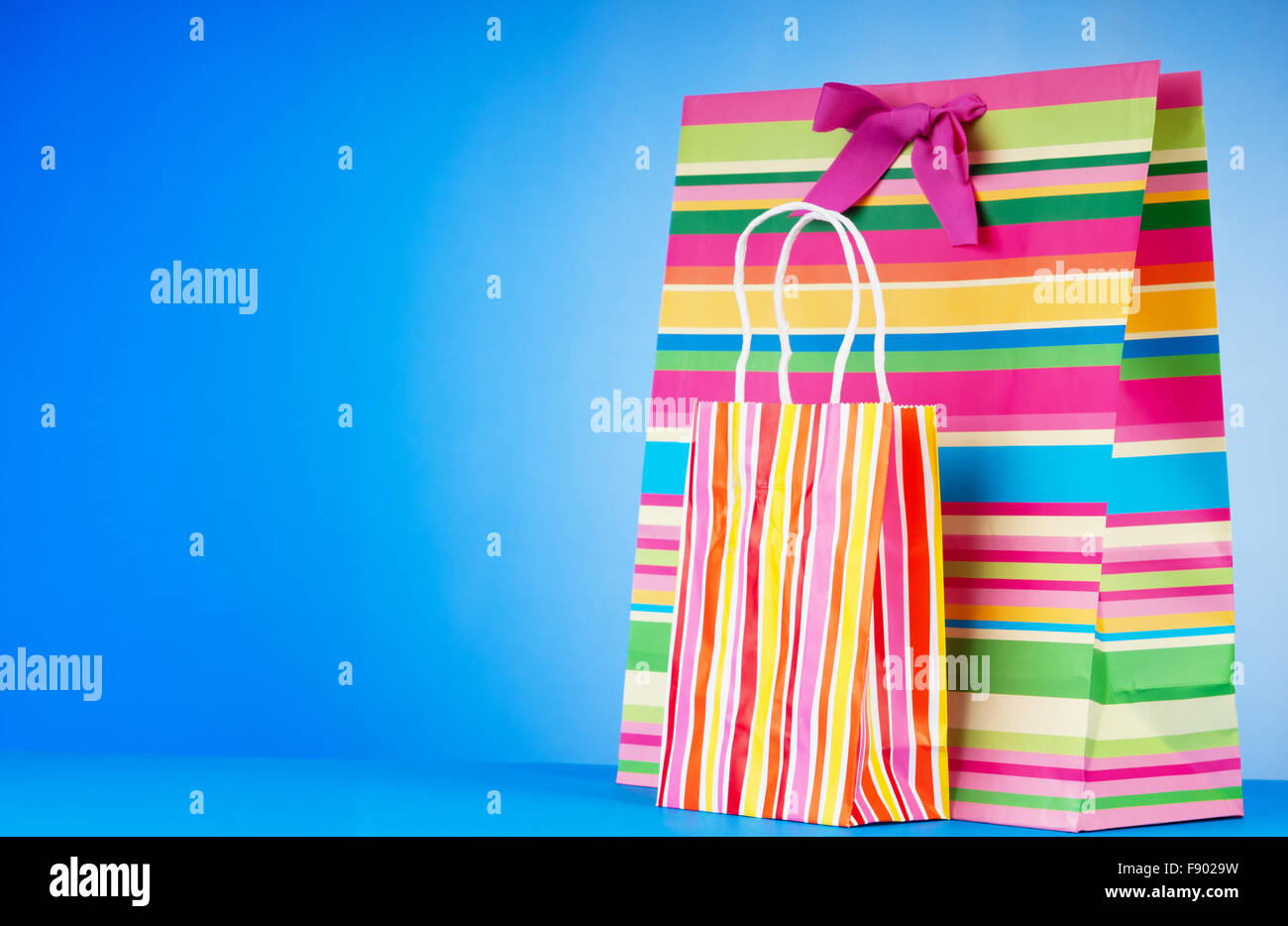 Colourful paper shopping bags against gradient background Stock Photo ...