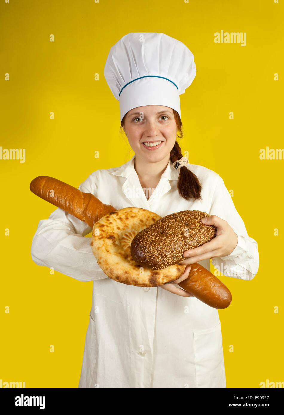 female baker with hands full of bread over yellow Stock Photo - Alamy