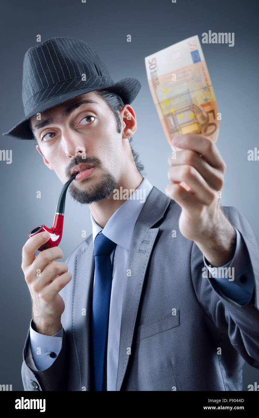 Detective looking at fake money Stock Photo - Alamy