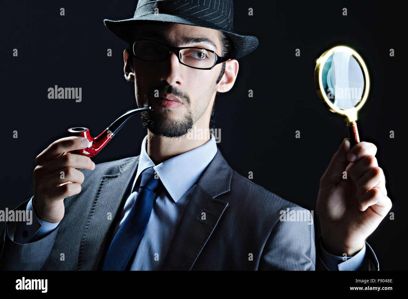 Detective with magnifying glass and pipe Stock Photo - Alamy