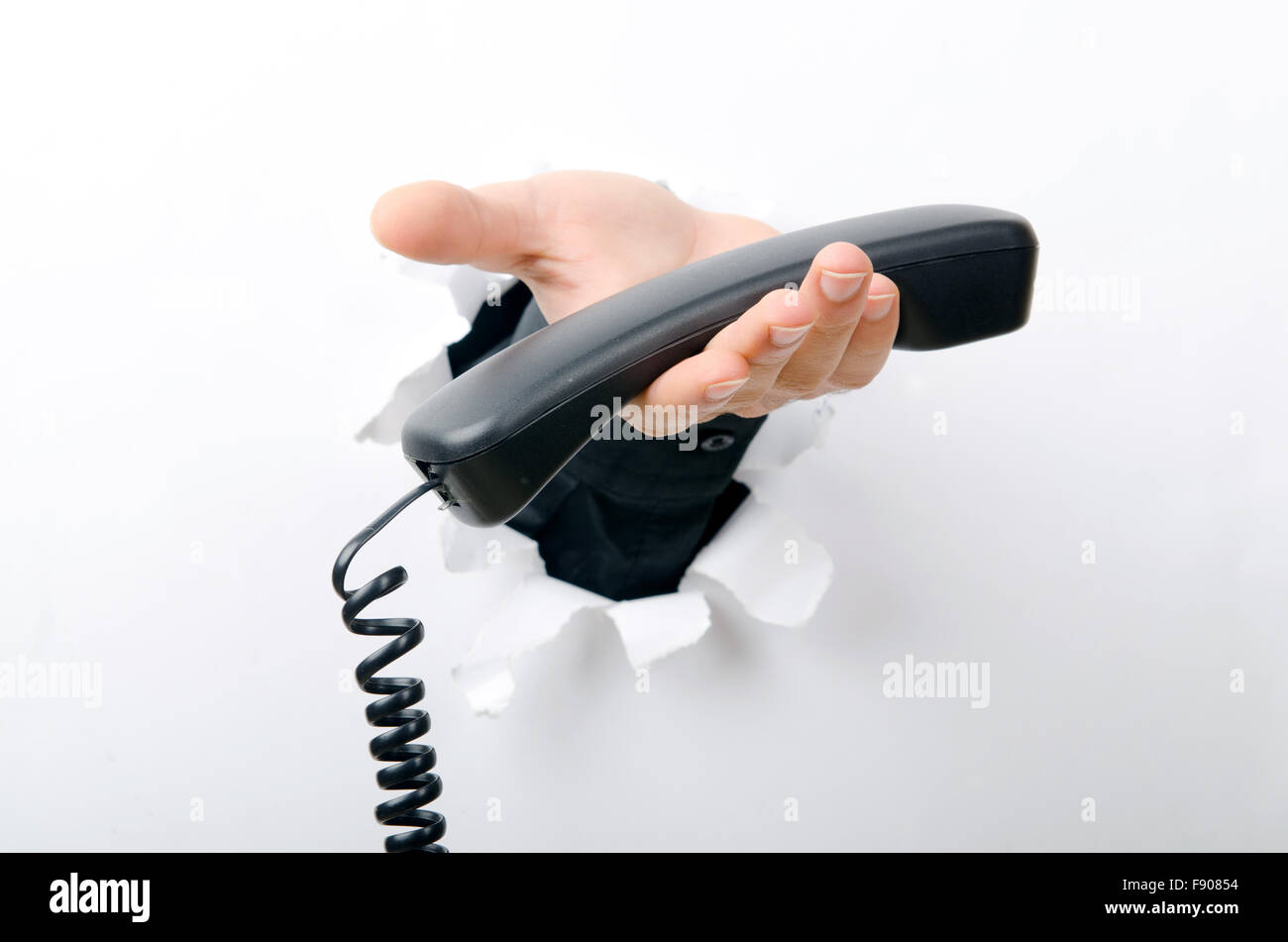 Hand holding phone through hole in paper Stock Photo - Alamy
