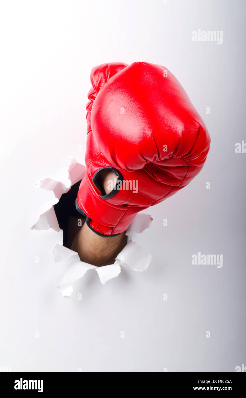 Hand in boxing glove through paper hole Stock Photo - Alamy
