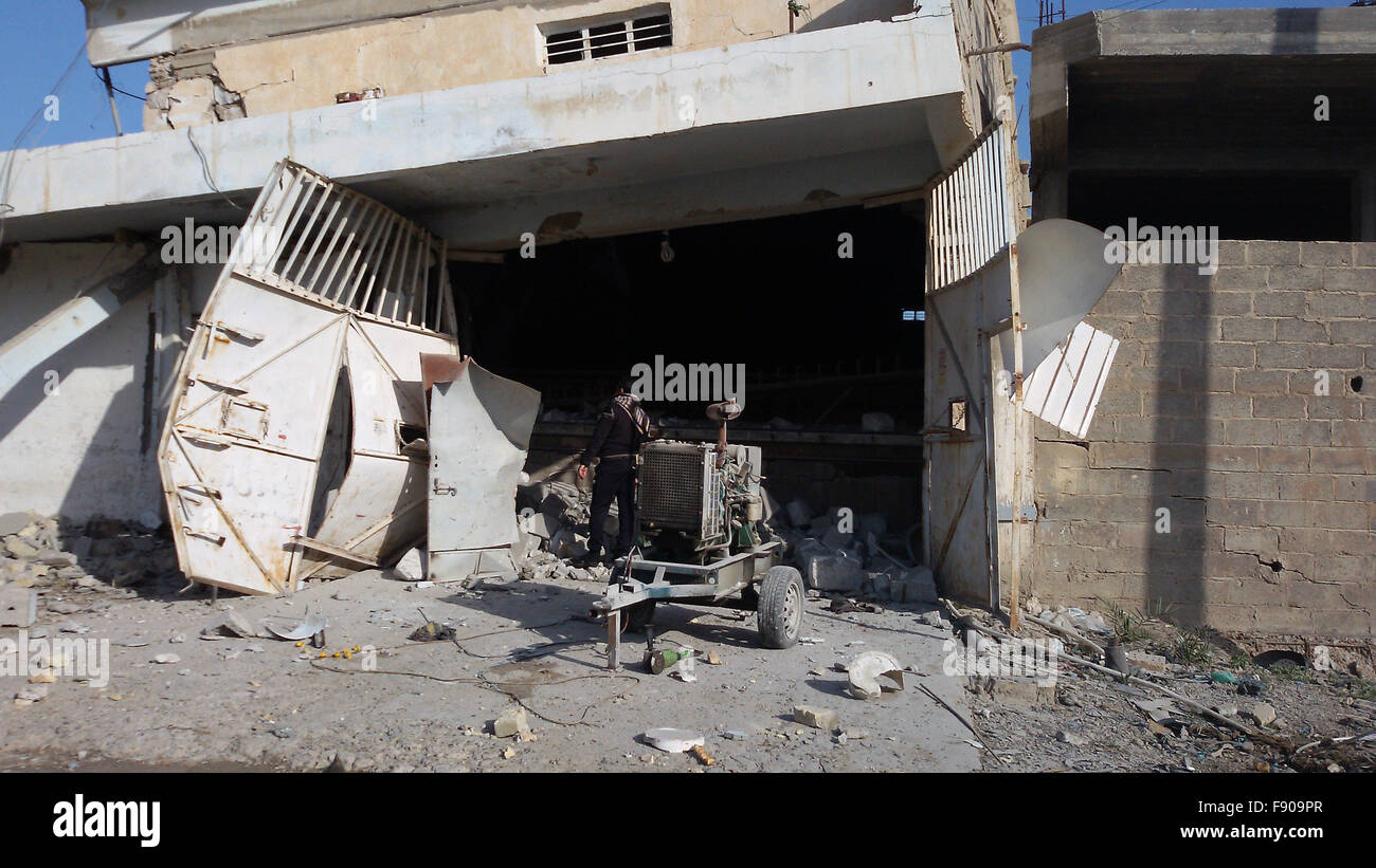 Fallujah, Iraq. 12th Dec, 2015. A man stands by a destroyed building ...