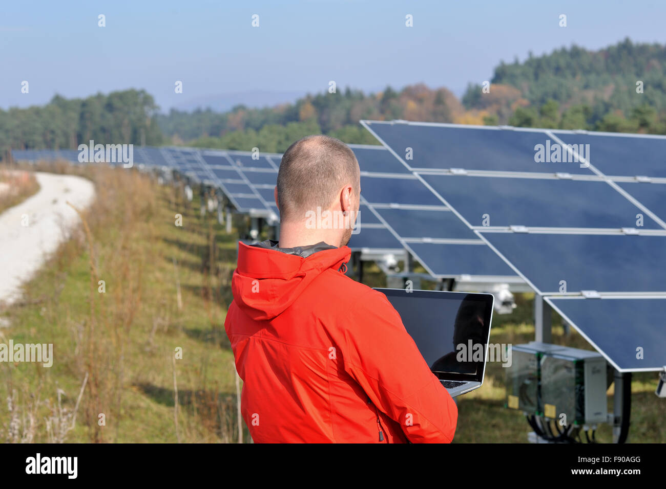 business man engineer using laptop at solar panels plant eco energy ...
