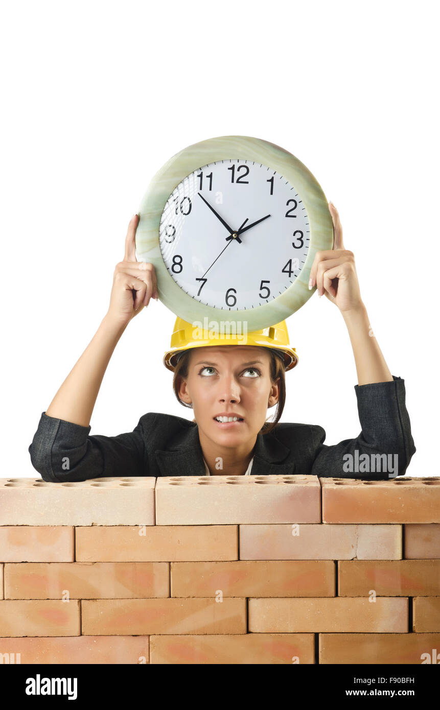 Female builder and clock on white Stock Photo - Alamy