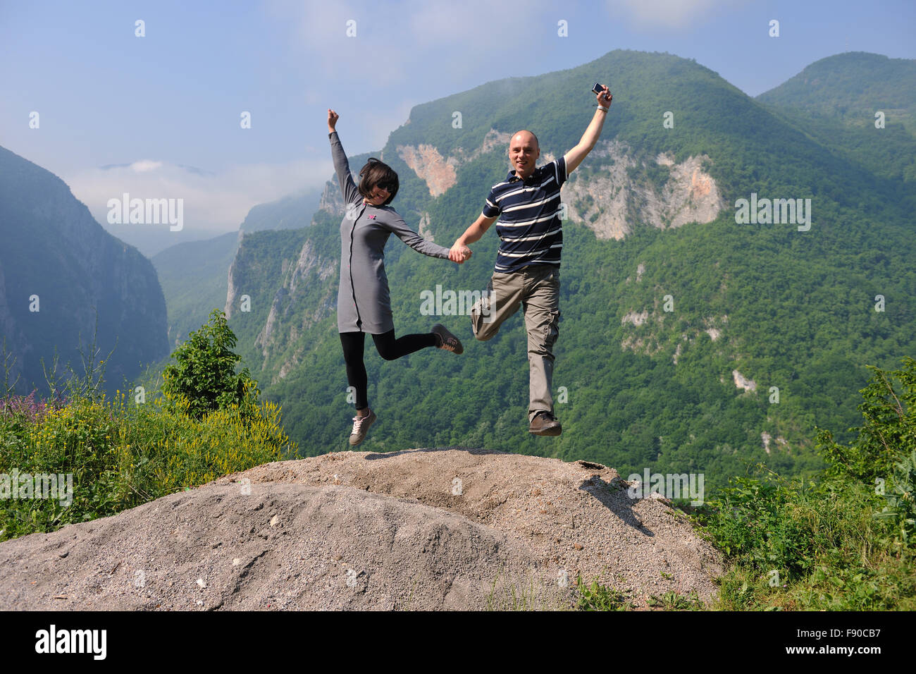 happy young couple in love jump in air in beautiful green and fresh ...