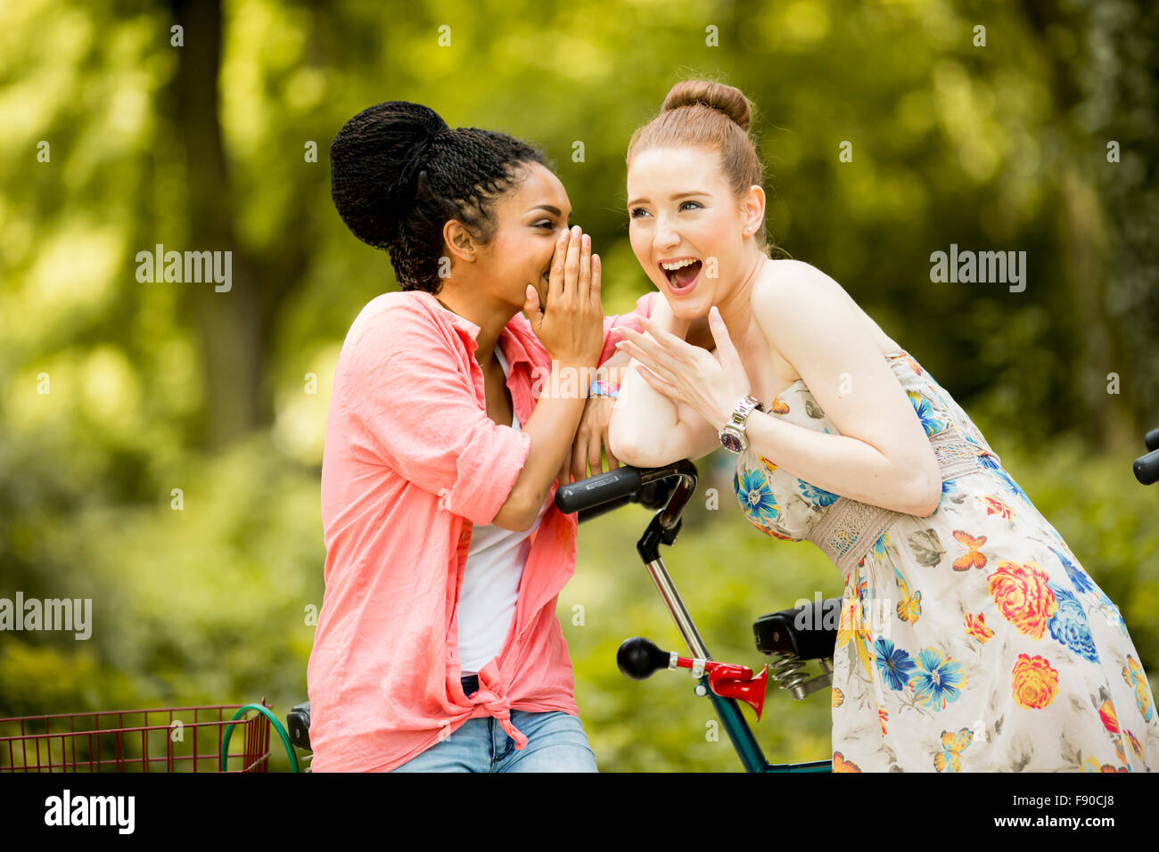Young women posing by the bicycle Stock Photo - Alamy