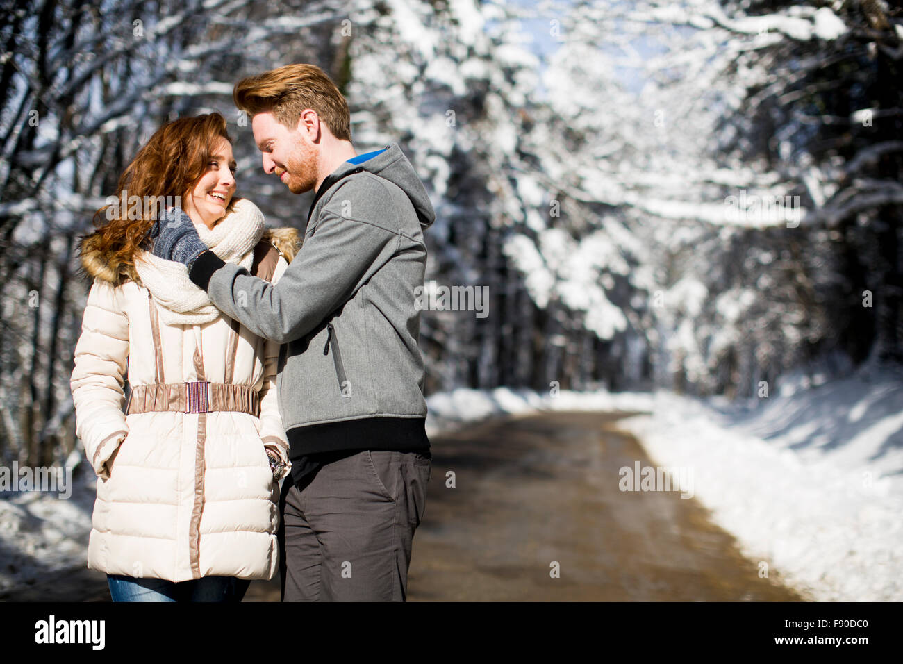 Loving young couple at winter forest Stock Photo - Alamy