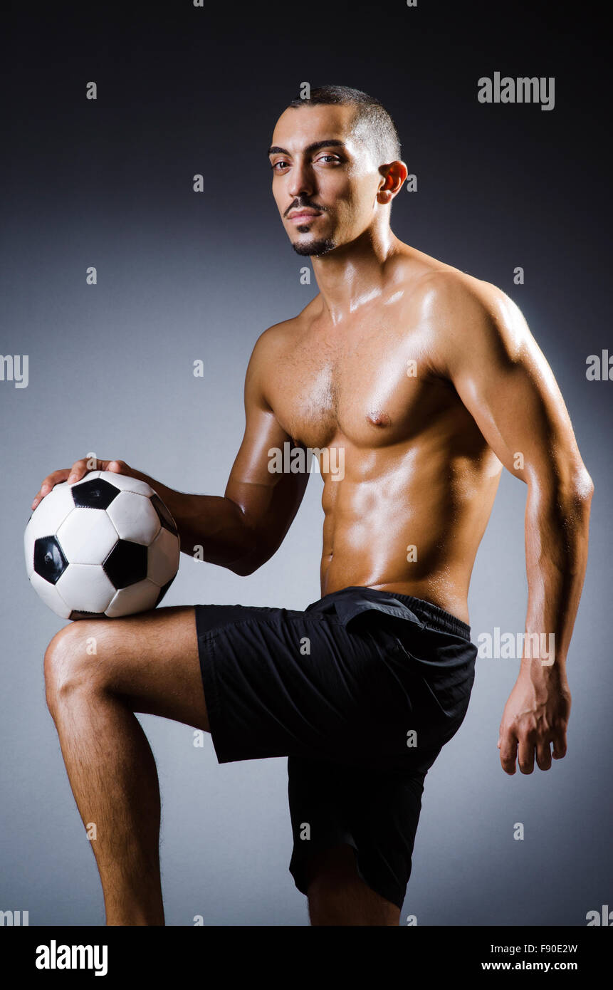 Muscular man with football ball Stock Photo - Alamy