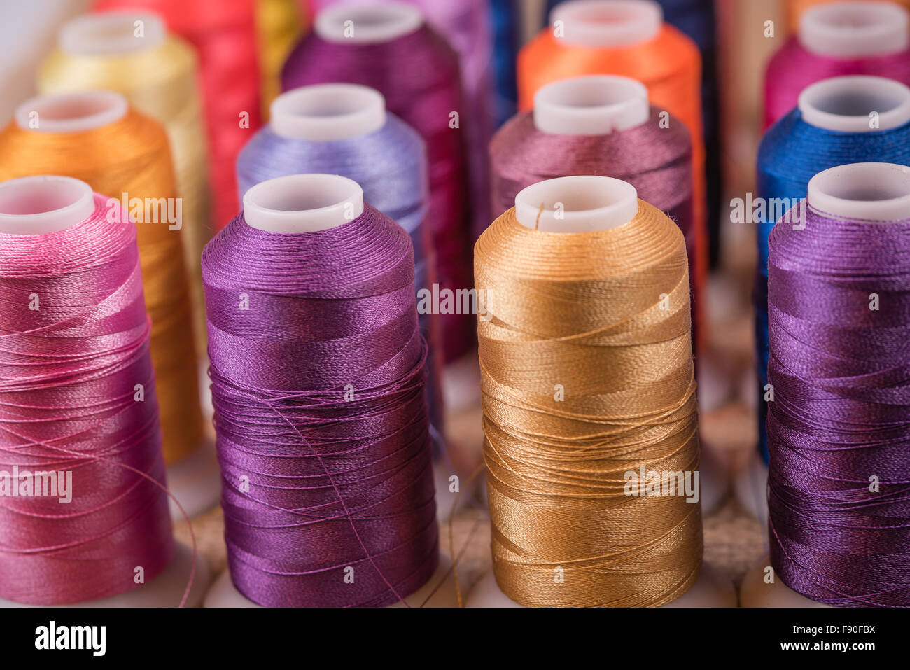 Spools of colorful thread lined in rows Stock Photo - Alamy