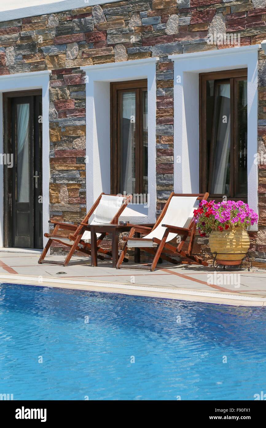 Chaise lounge around swimming pool at a sunny day Stock Photo - Alamy