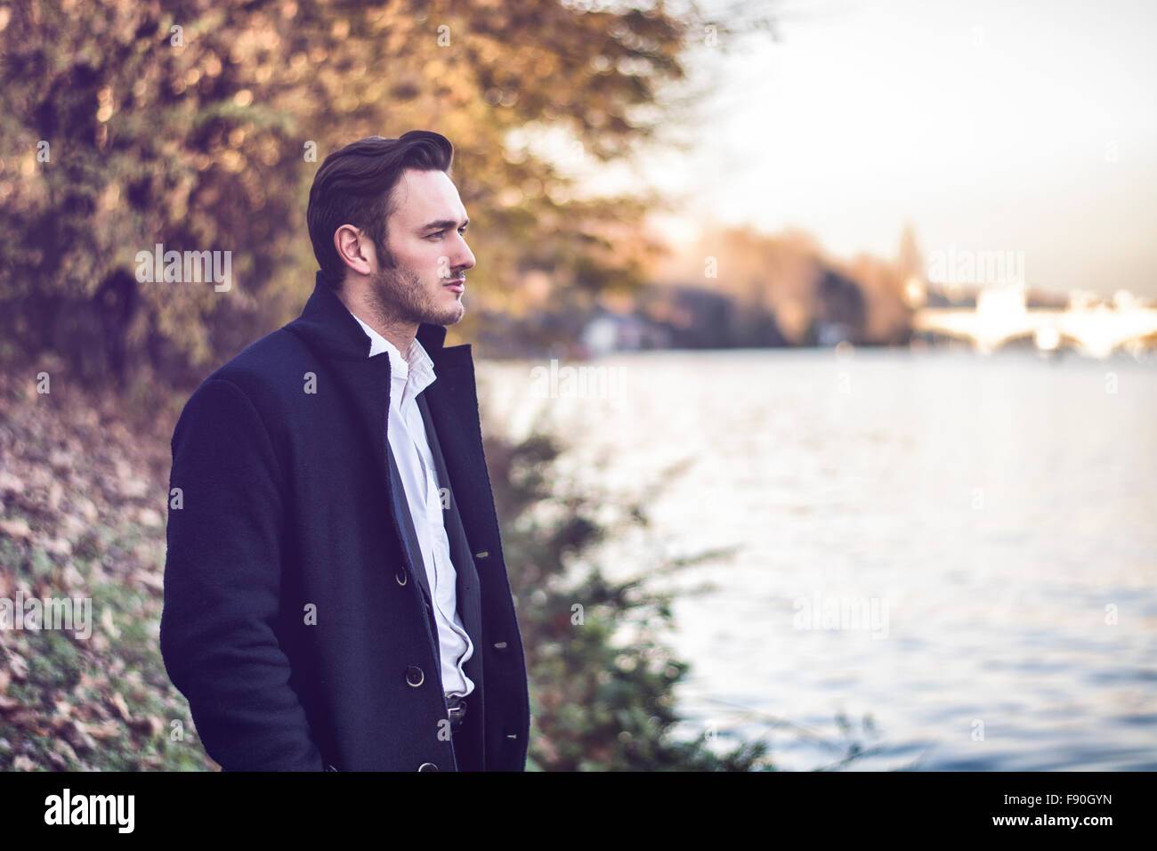 Handsome young man outdoor in winter fashion, wearing black coat and ...