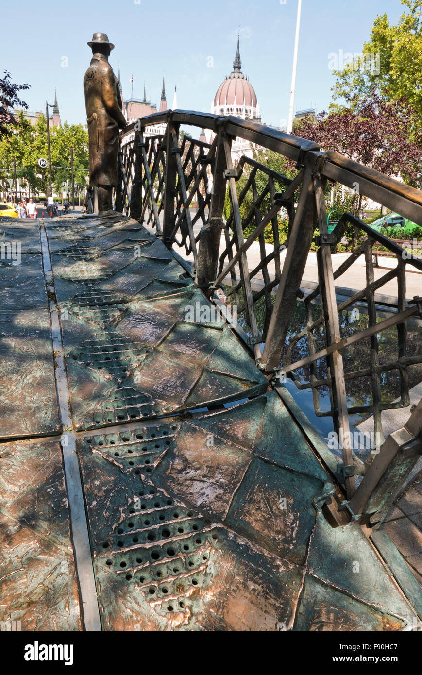 A sculpture of Imre Nagy, a man on a small bridge facing the Parliament ...