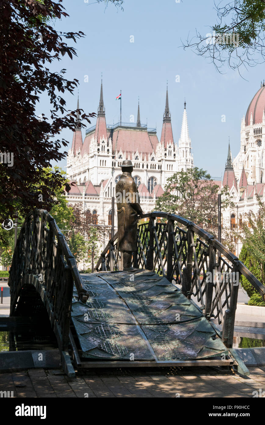 A sculpture of Imre Nagy, a man on a small bridge facing the Parliament ...