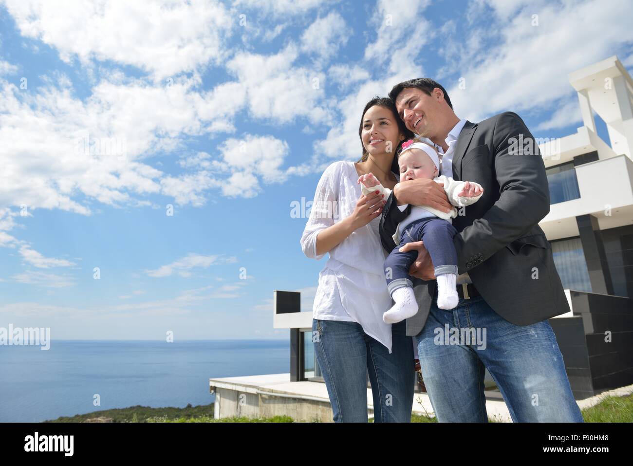 happy young family couple with beautiful new born baby have fun at home ...