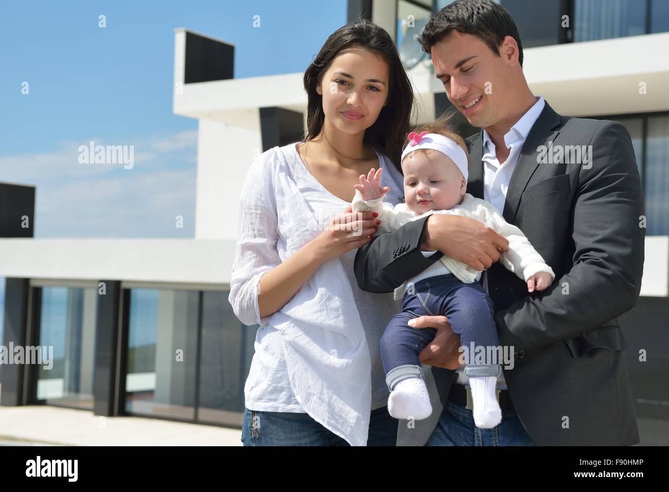 happy young family couple with beautiful new born baby have fun at home ...