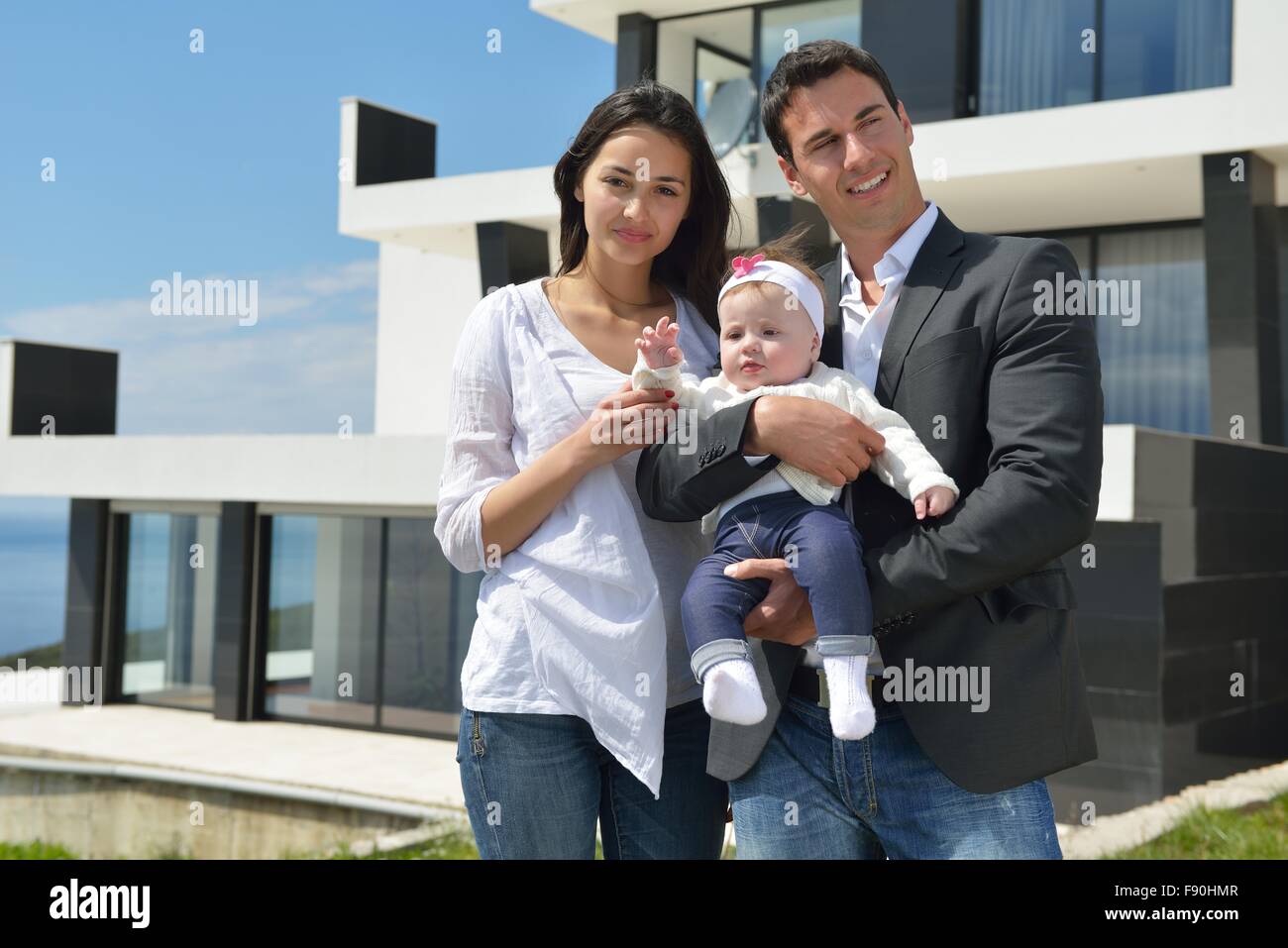 happy young family couple with beautiful new born baby have fun at home ...