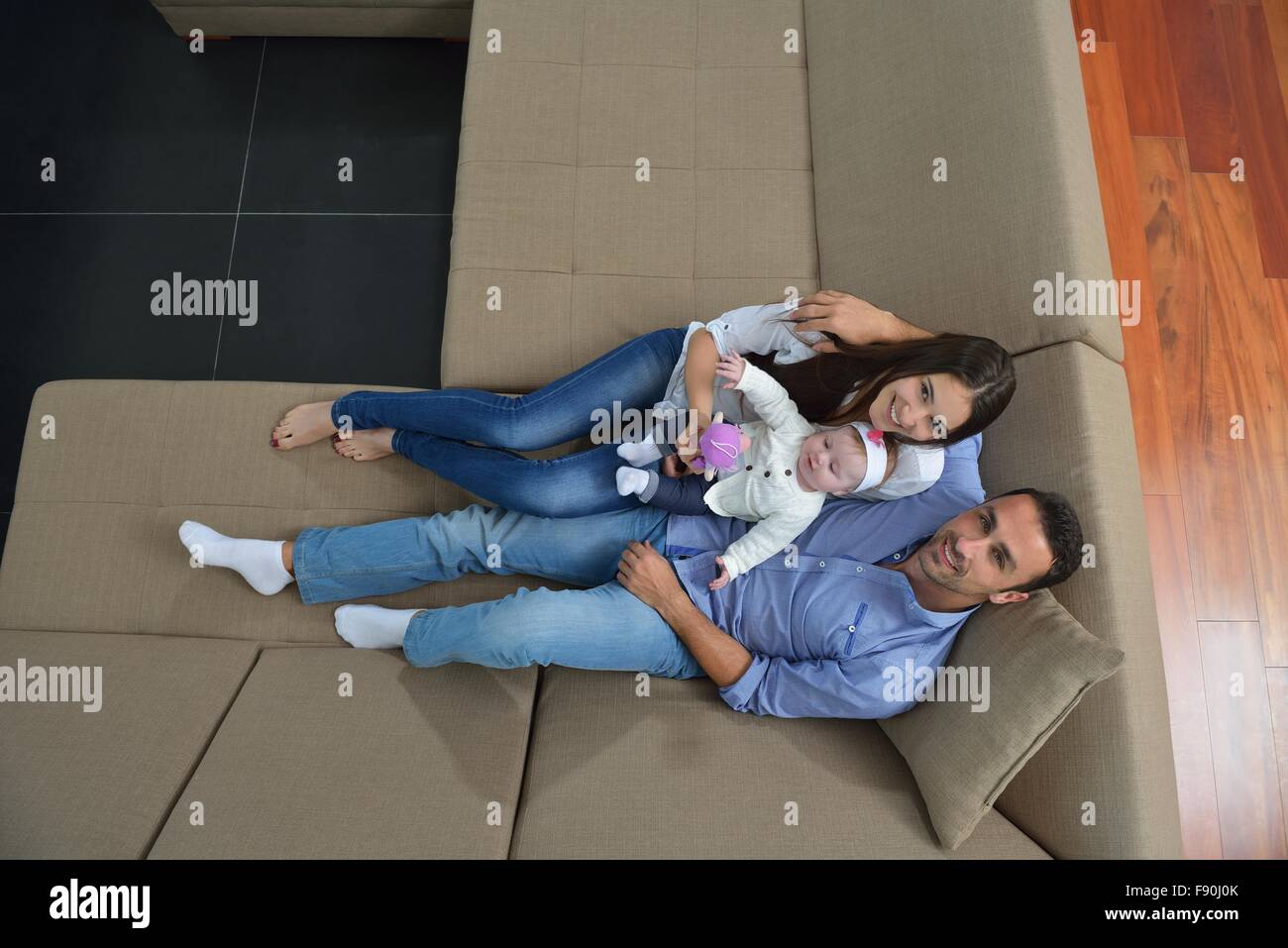 happy young family couple with beautiful new born baby have fun at home ...