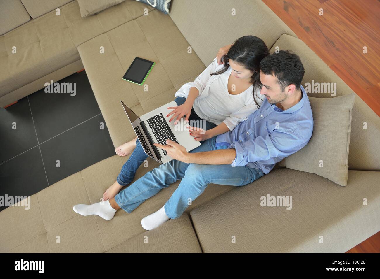 happy young relaxed couple working and playing on laptop computer at ...