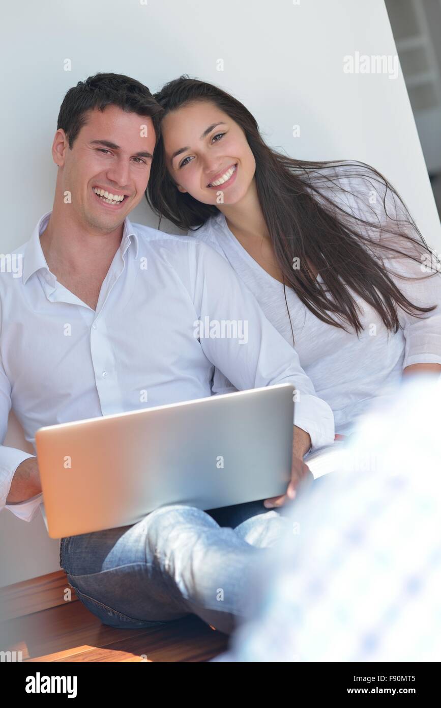 happy young relaxed couple working and playing on laptop computer at ...