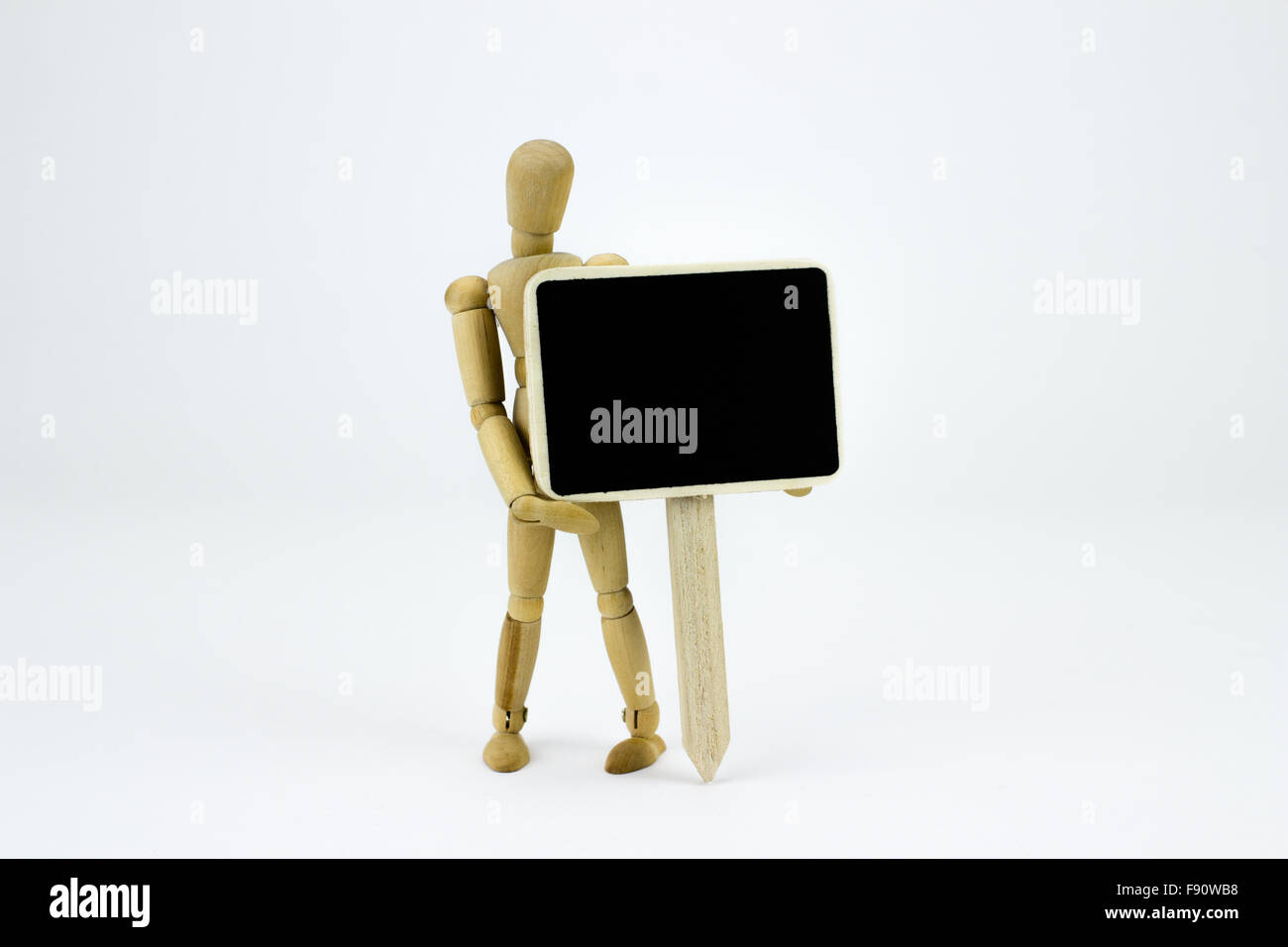 Wooden man with sign in front of white background Stock Photo - Alamy