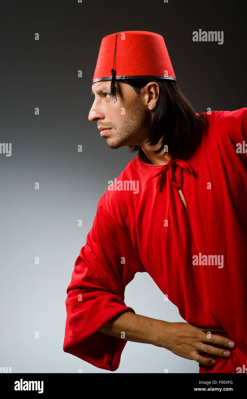 Funny man in red dress wearing fez hat Stock Photo - Alamy