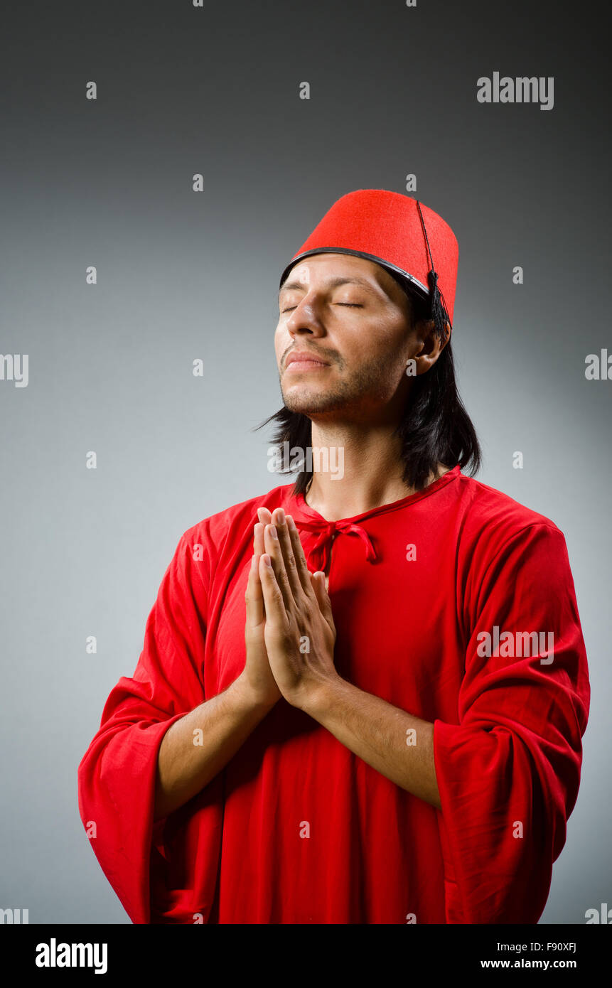 Man in red dress wearing fez hat Stock Photo - Alamy