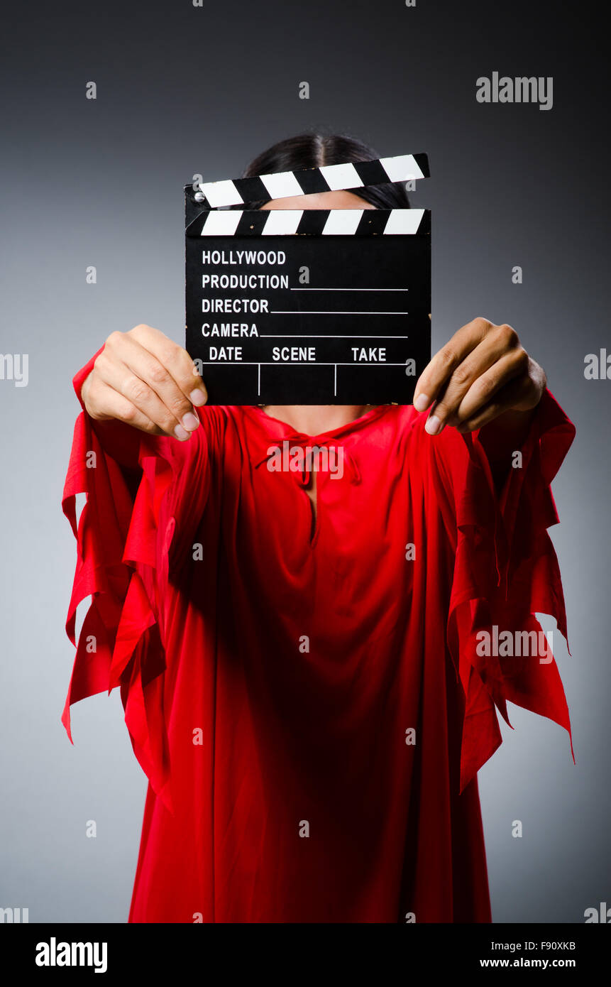 Man in red dress with movie clapboard Stock Photo - Alamy