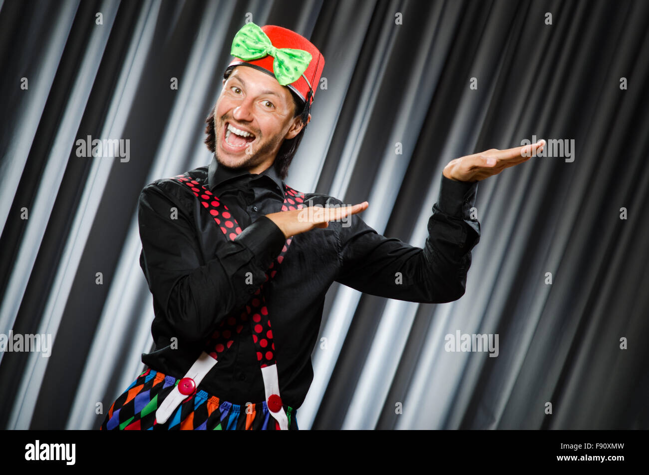 Funny clown in humorous concept against curtain Stock Photo - Alamy