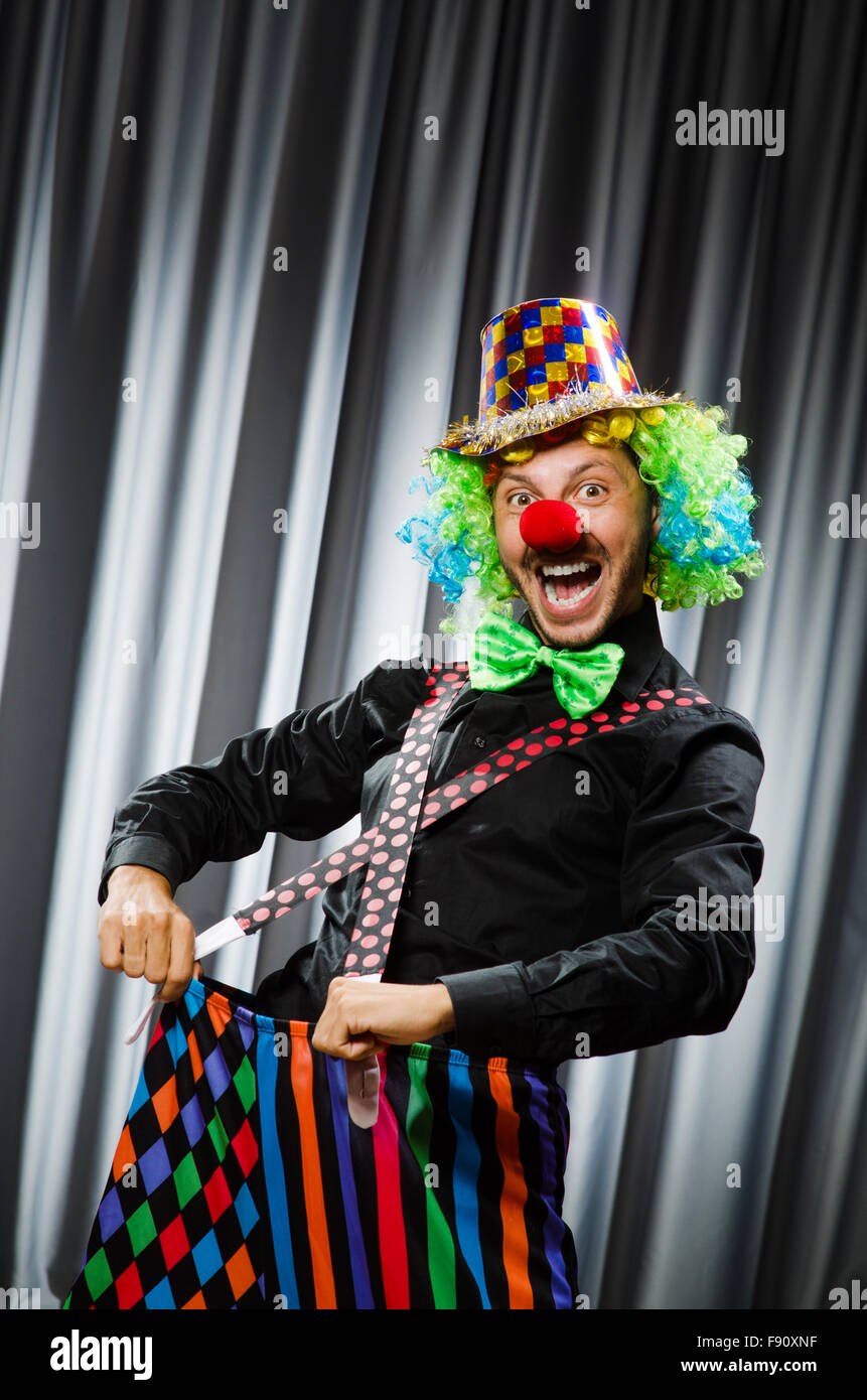 Funny clown in humorous concept against curtain Stock Photo - Alamy