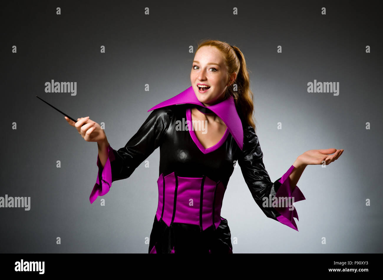 Female magician doing tricks on grey background Stock Photo - Alamy