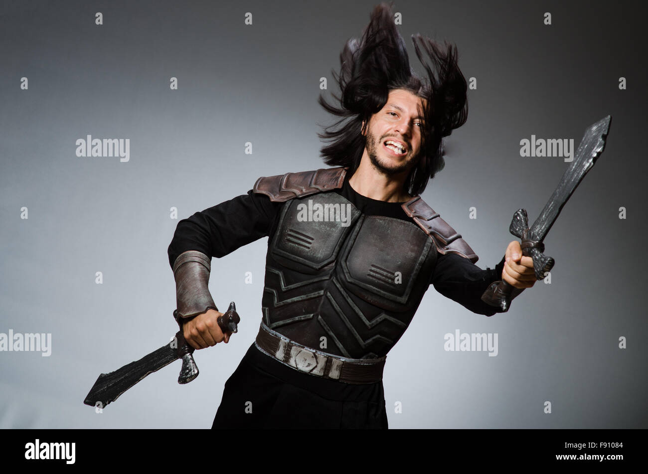 Angry knight with sword against dark background Stock Photo - Alamy