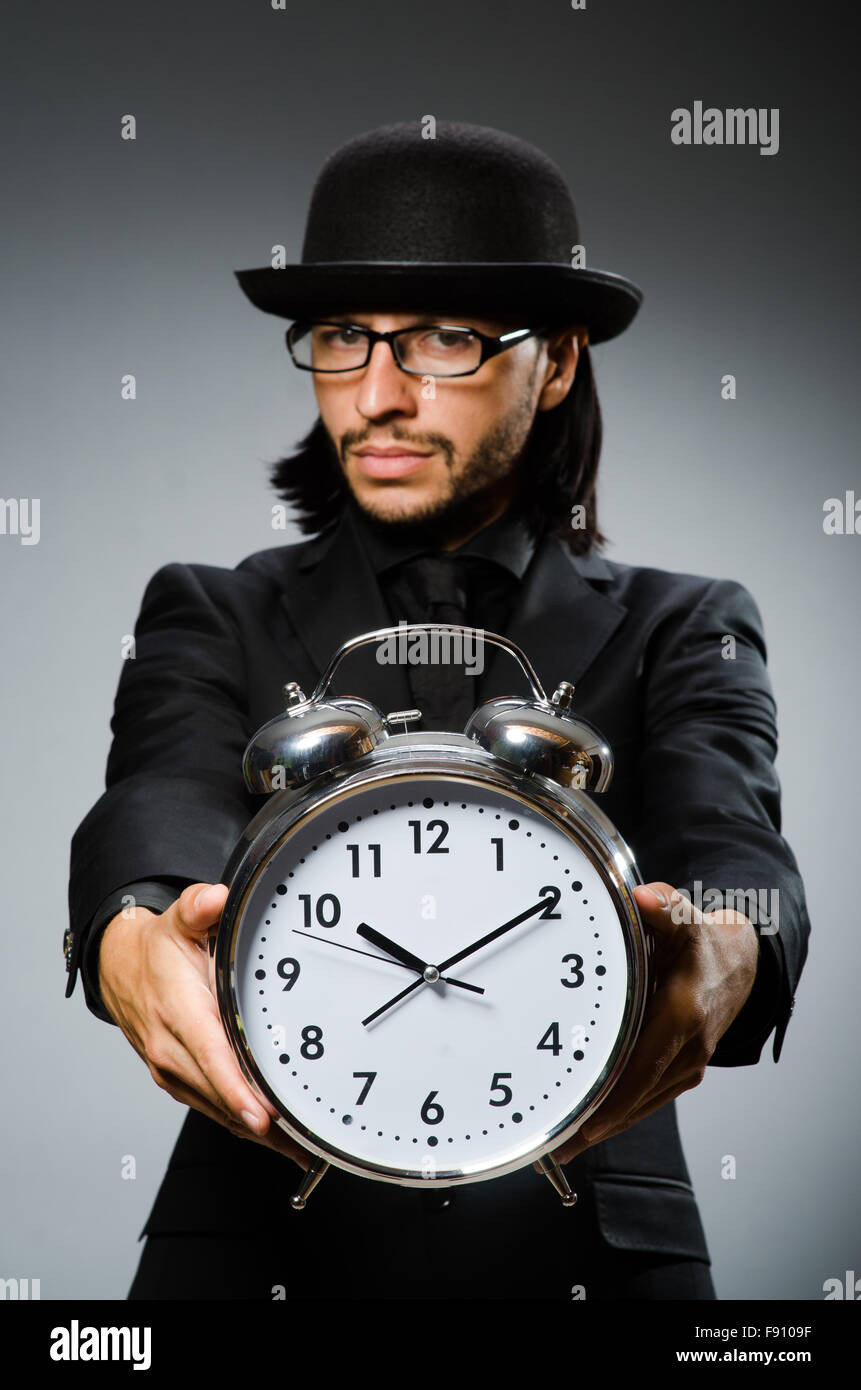 Man with clock wearing vintage hat Stock Photo - Alamy