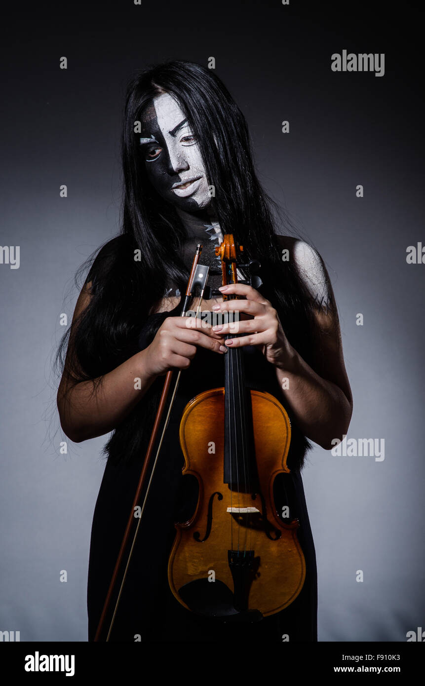 Scary monster playing violing in halloween concept Stock Photo - Alamy