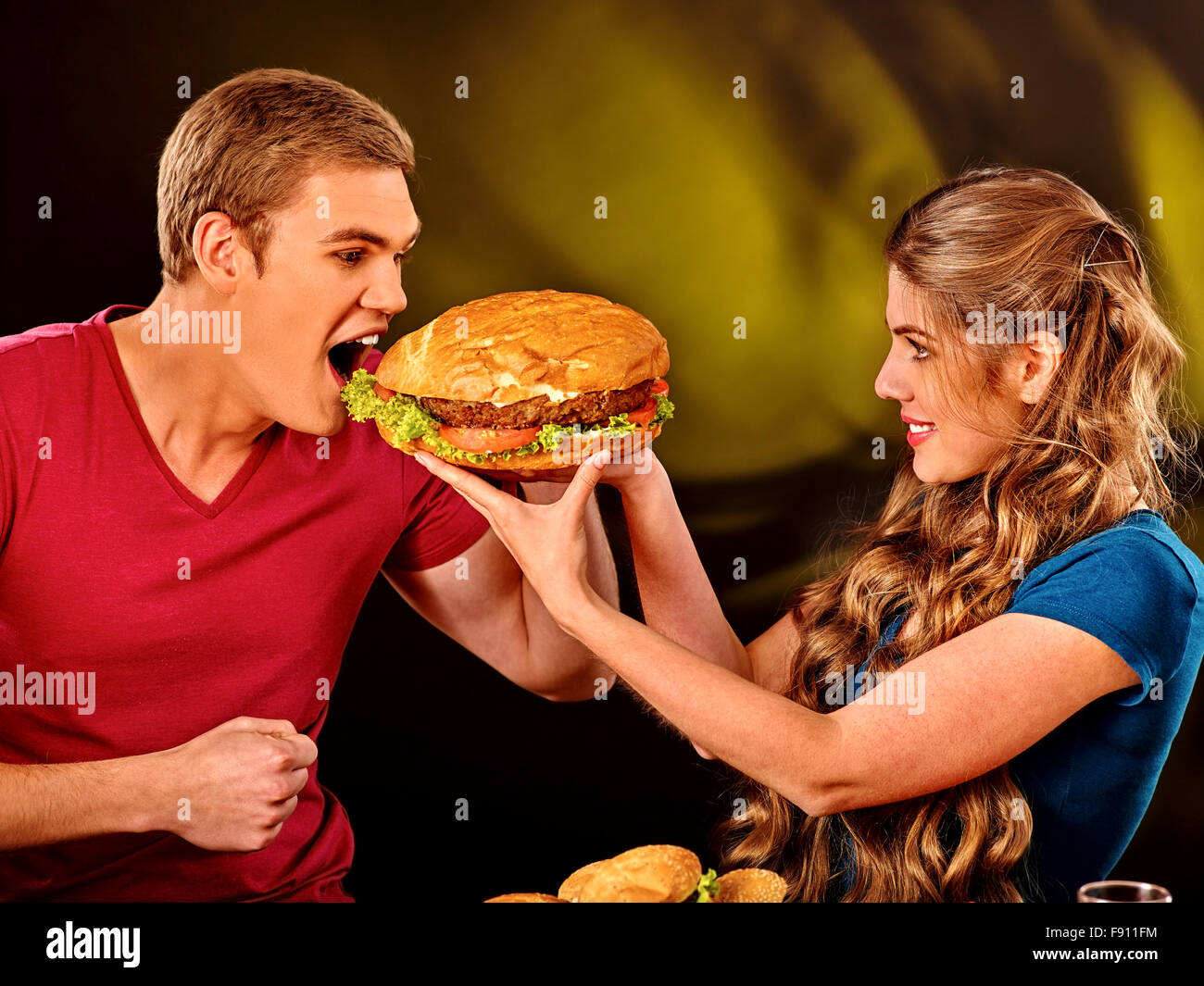 Woman feeds man fast food Stock Photo - Alamy