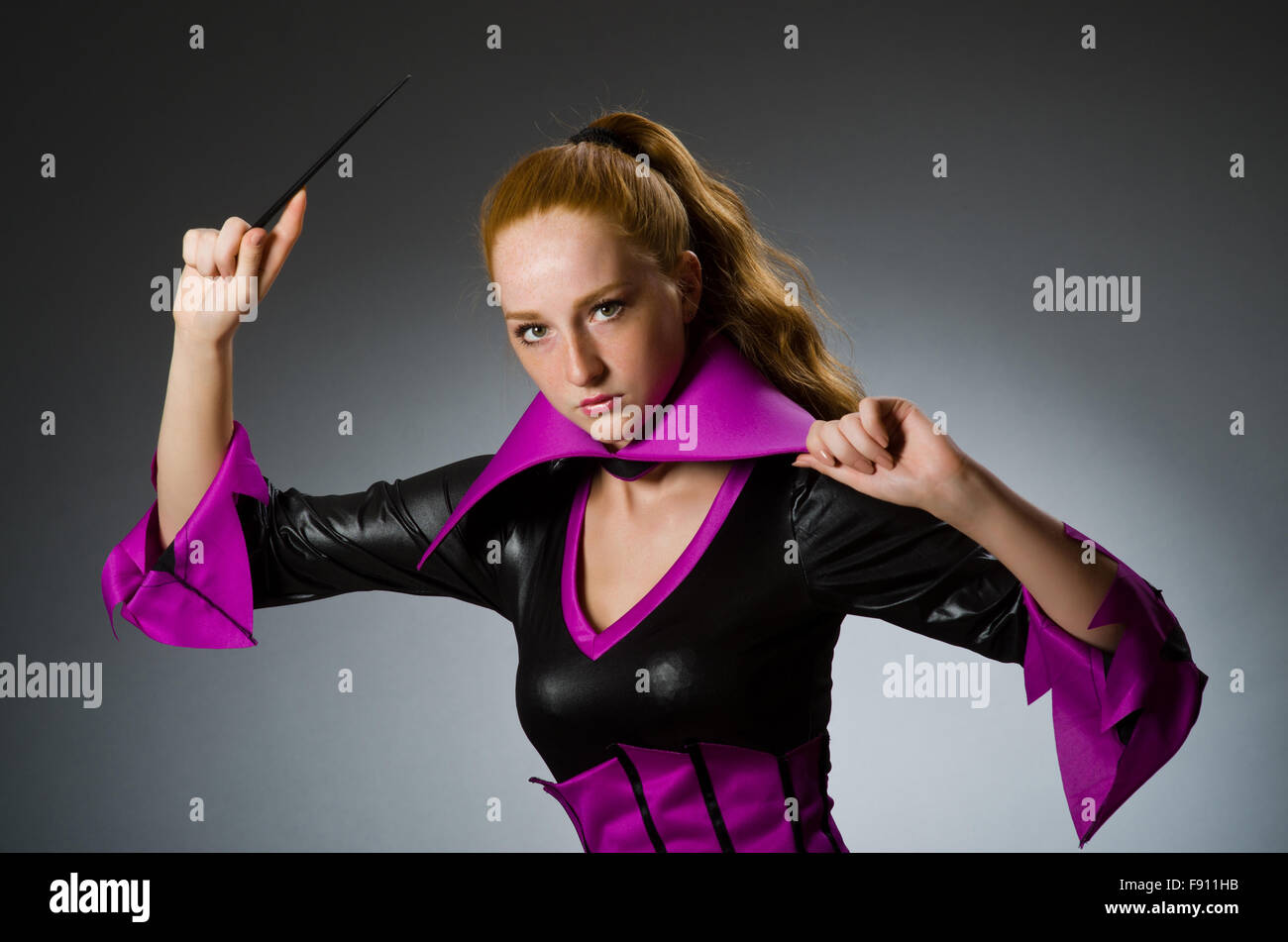 Female magician doing tricks on grey background Stock Photo - Alamy