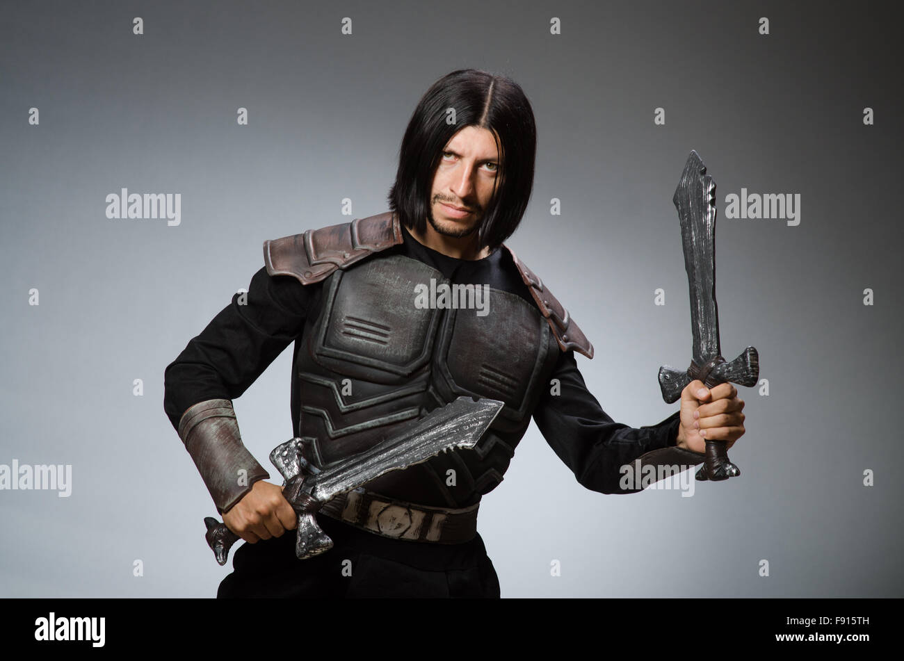 Angry knight with sword against dark background Stock Photo - Alamy