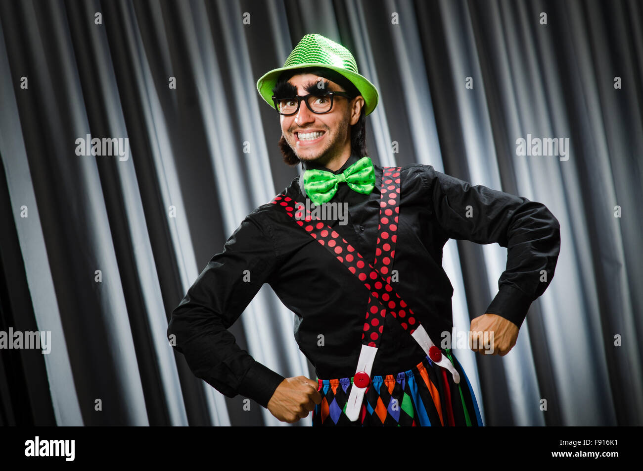 Funny clown in humorous concept against curtain Stock Photo - Alamy